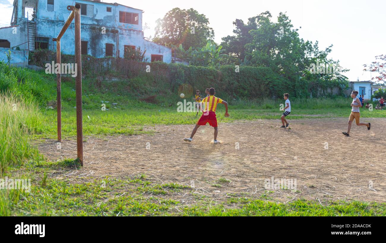 Cuban young people playing soccer or football in an abandoned field ...