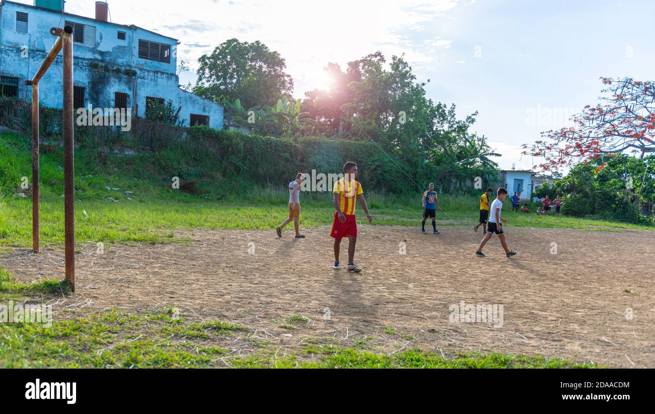 Cuban young people playing soccer or football in an abandoned field ...