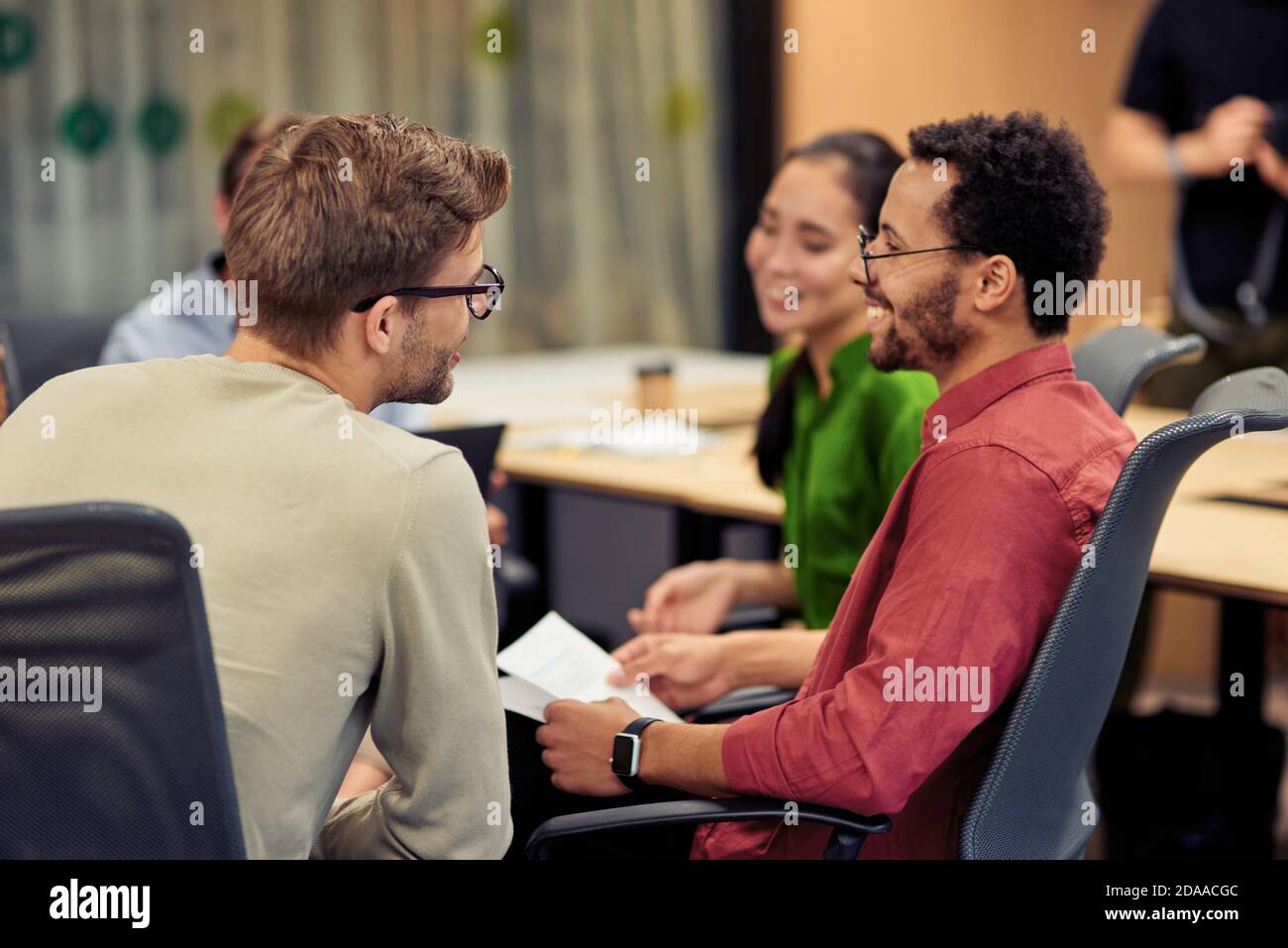 Group of young happy multi racial coworkers communicating and sharing ...
