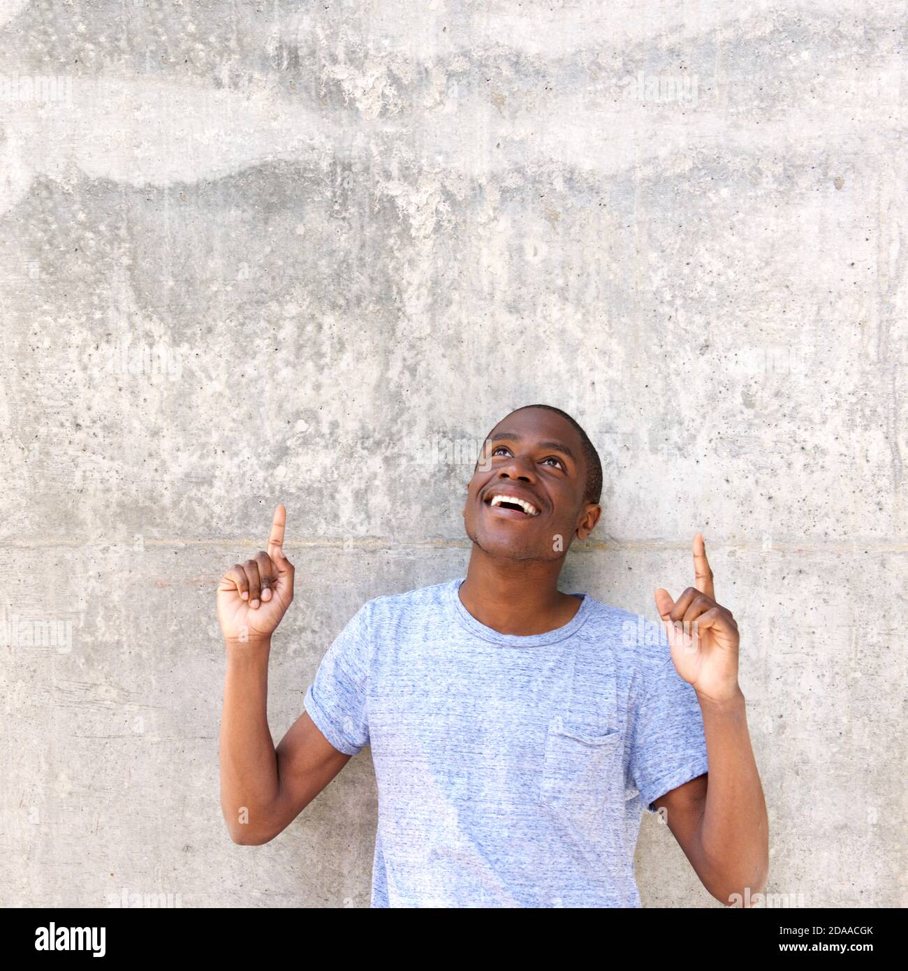 Portrait of smiling black guy pointing fingers up Stock Photo - Alamy