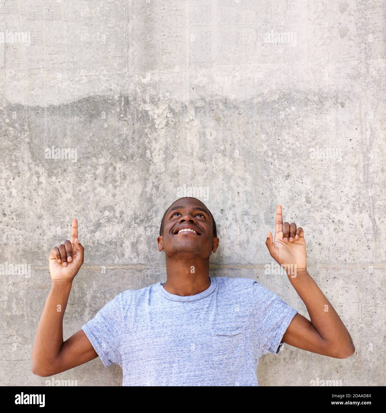 Portrait of happy african man raising head and hands pointing up Stock ...