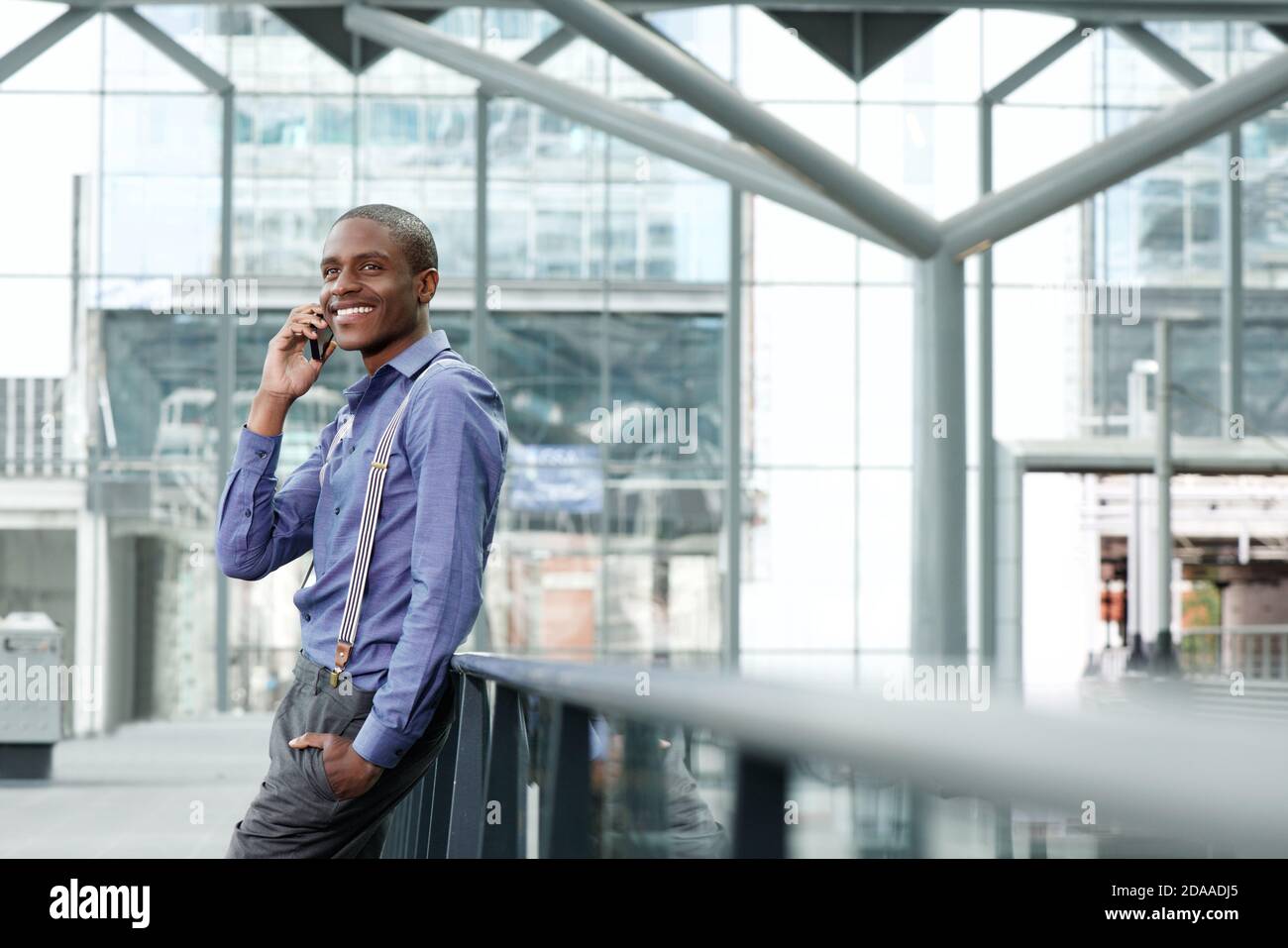 Side portrait of a cool african businessman smiling with cellphone in ...