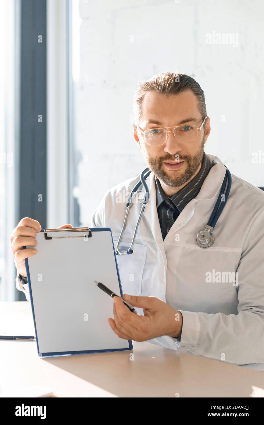 Vertical photo. Medical doctor during online consultation. He explains ...