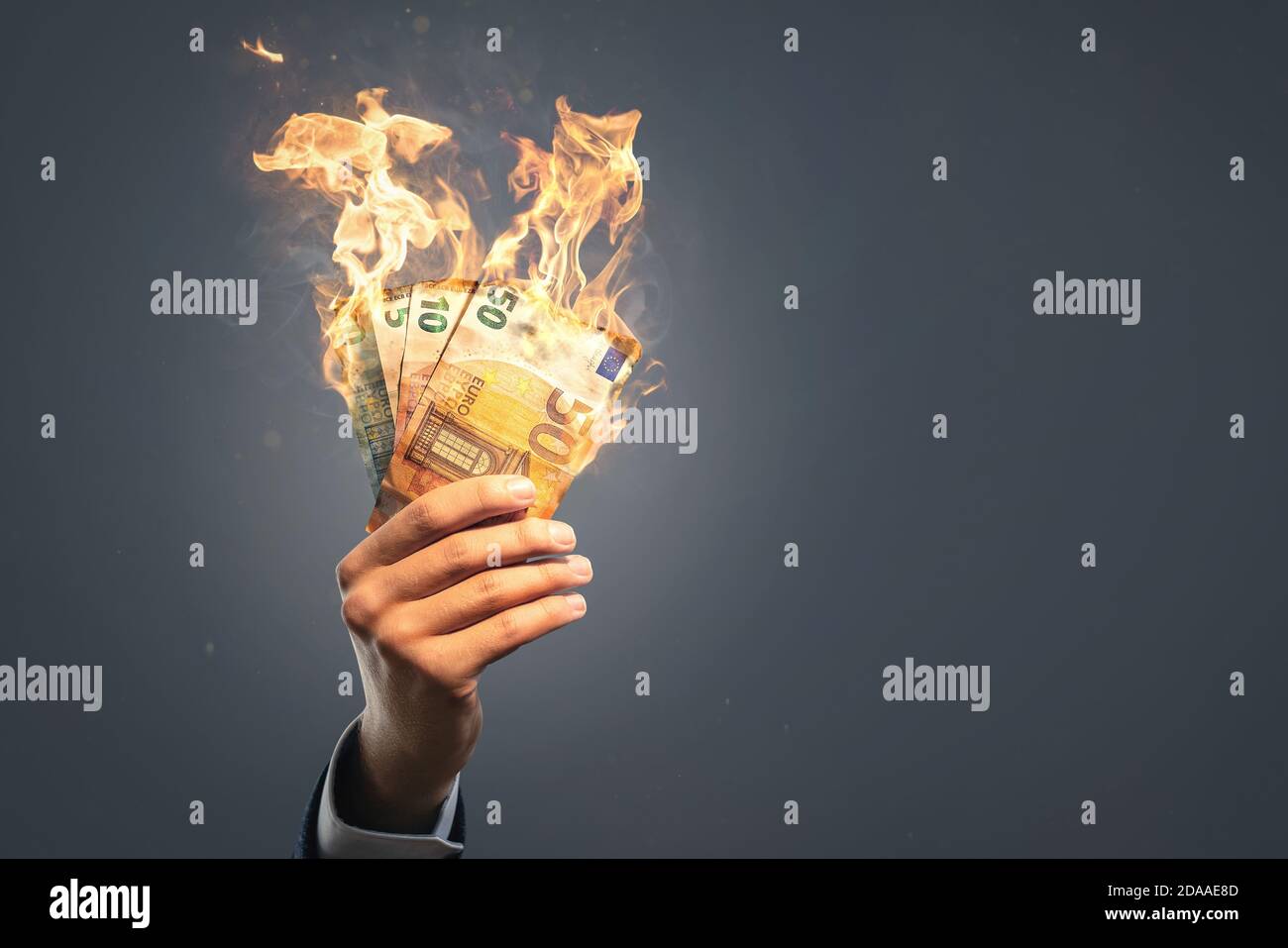 Hand holding burning Euro banknotes Stock Photo - Alamy
