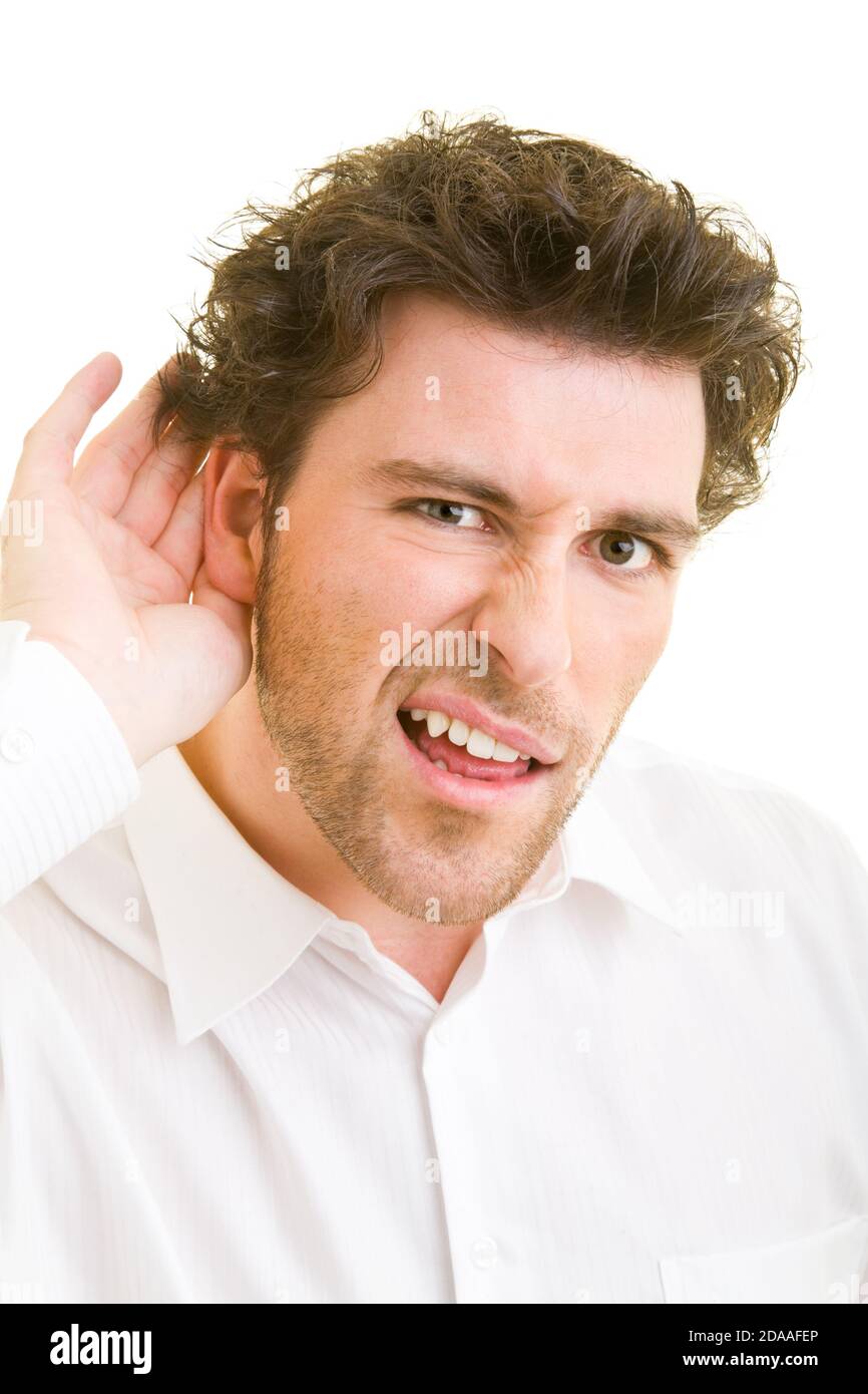 Young man listens with his hand behind his ear Stock Photo - Alamy