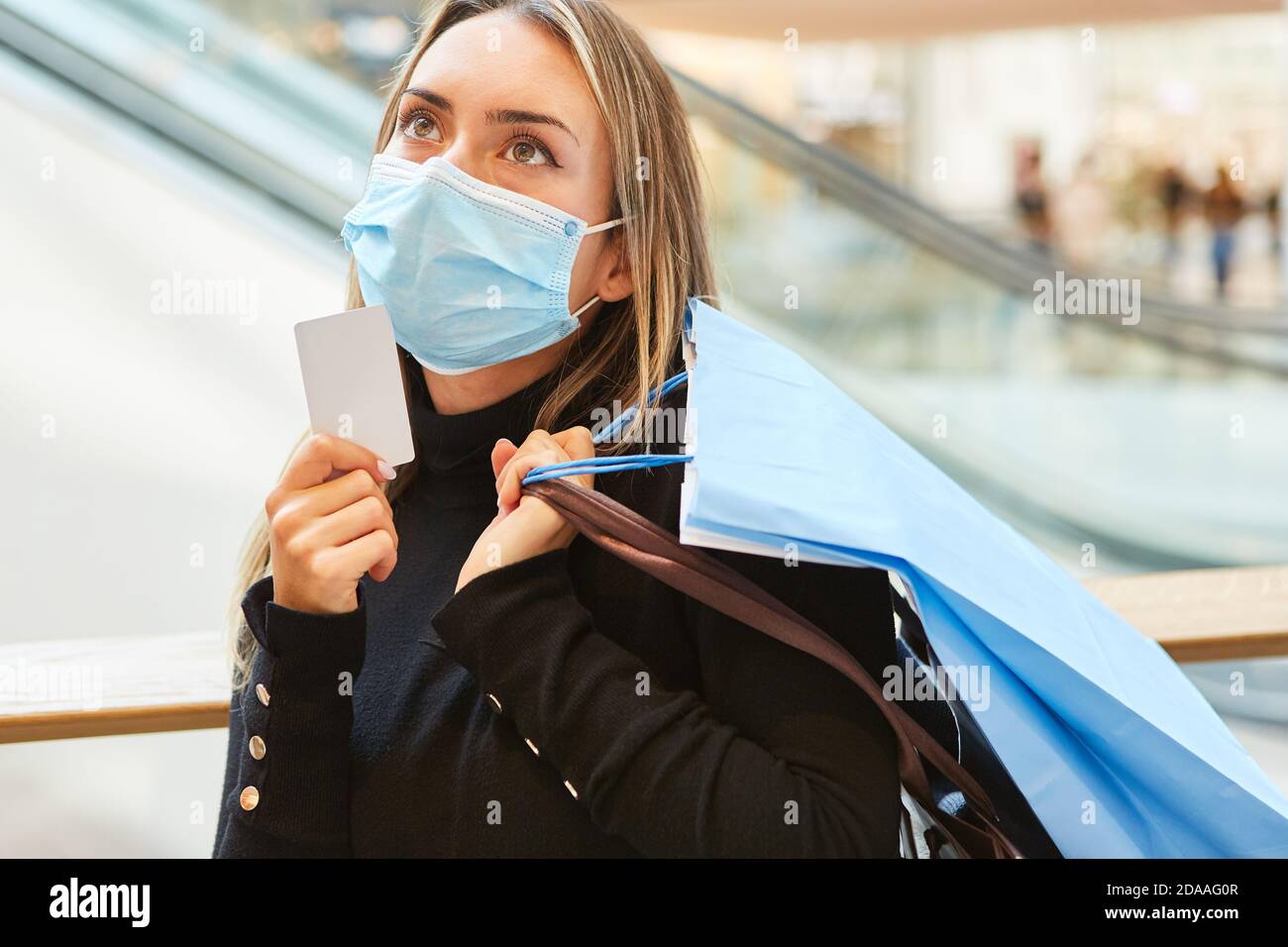 Customer with mask due to Covid-19 pandemic while shopping holds her ...