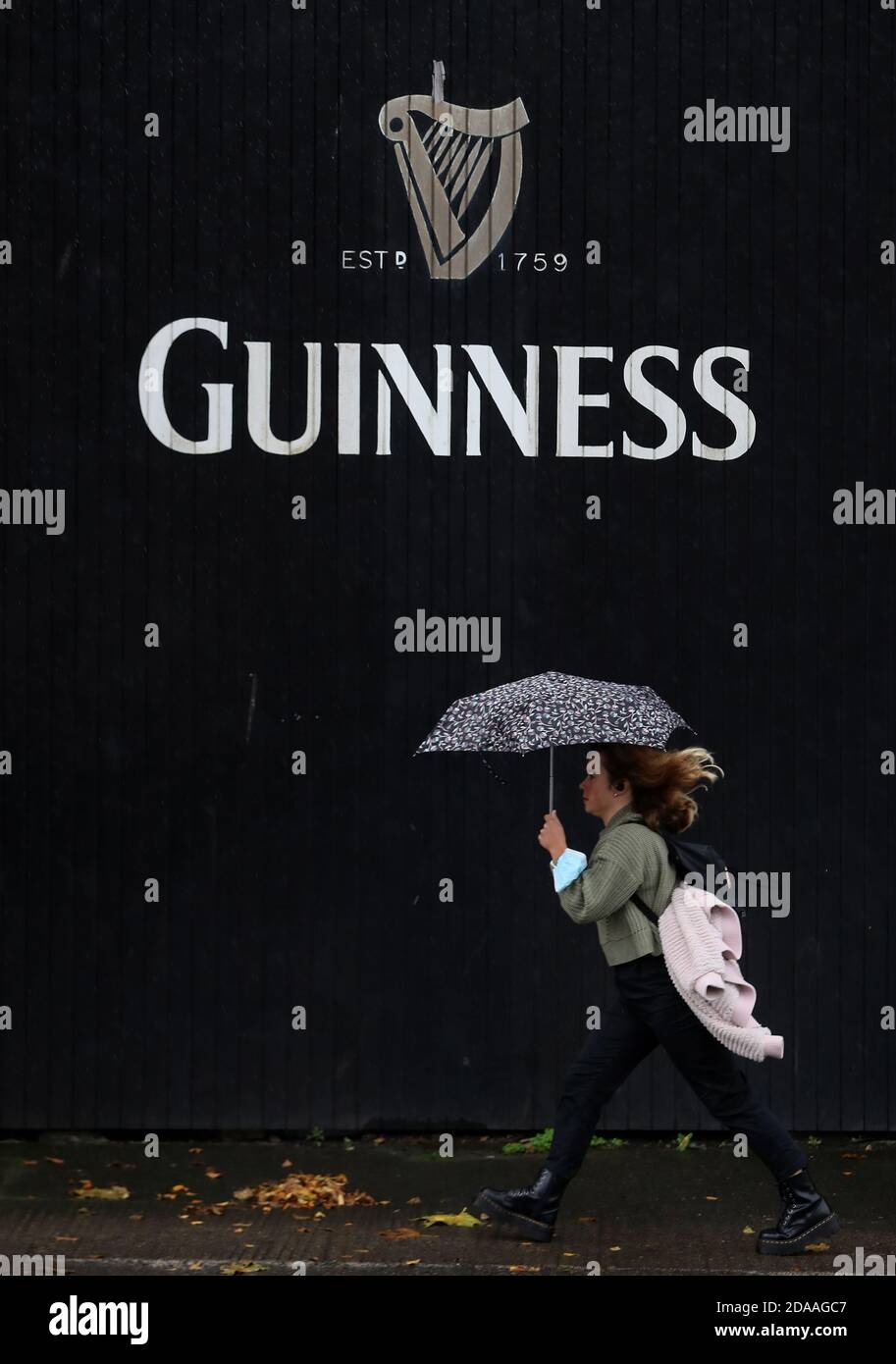 A woman passes the Guinness brewery in Dublin's city centre as Guinness ...