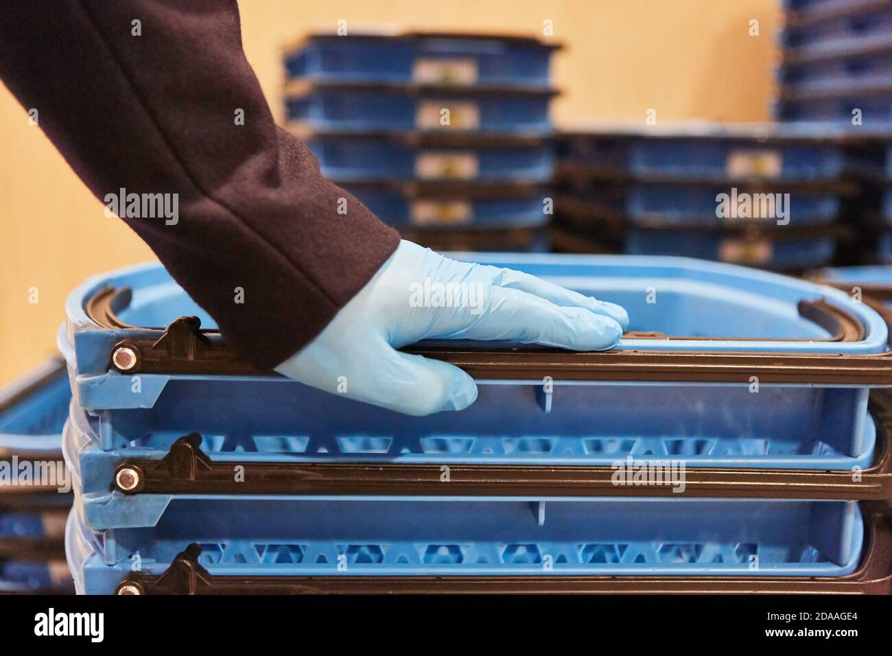 Hand of customer in disposable gloves on shopping basket due to Covid ...