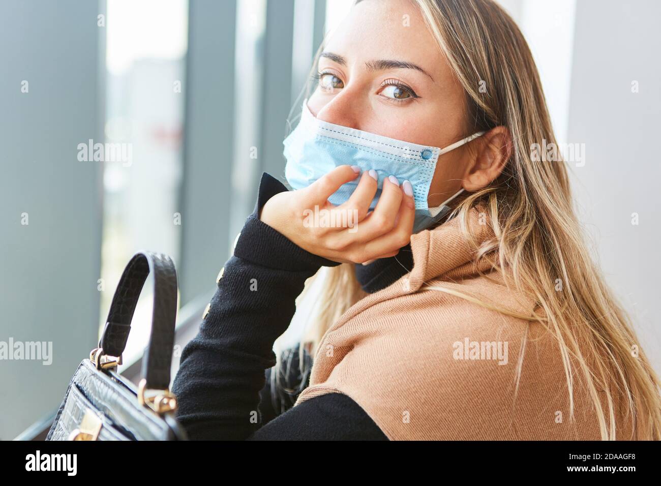 Young woman with face mask due to Covid-19 pandemic looks fearful and ...