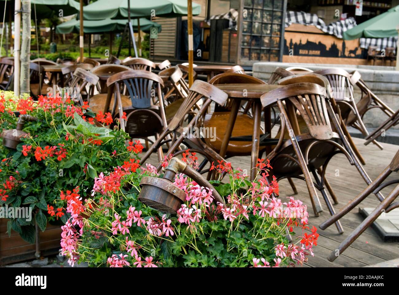 Closed cafe restaurant with wood chairs, stacked upon tables outdoor in ...