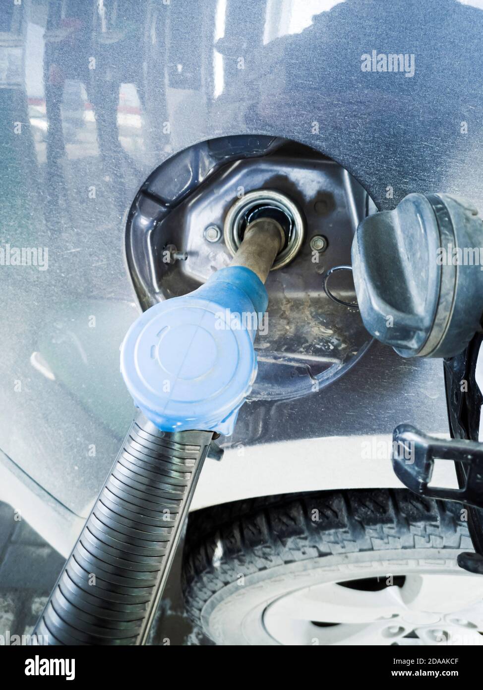 Car at gas station being filled with fuel. Close up refueling gun in ...