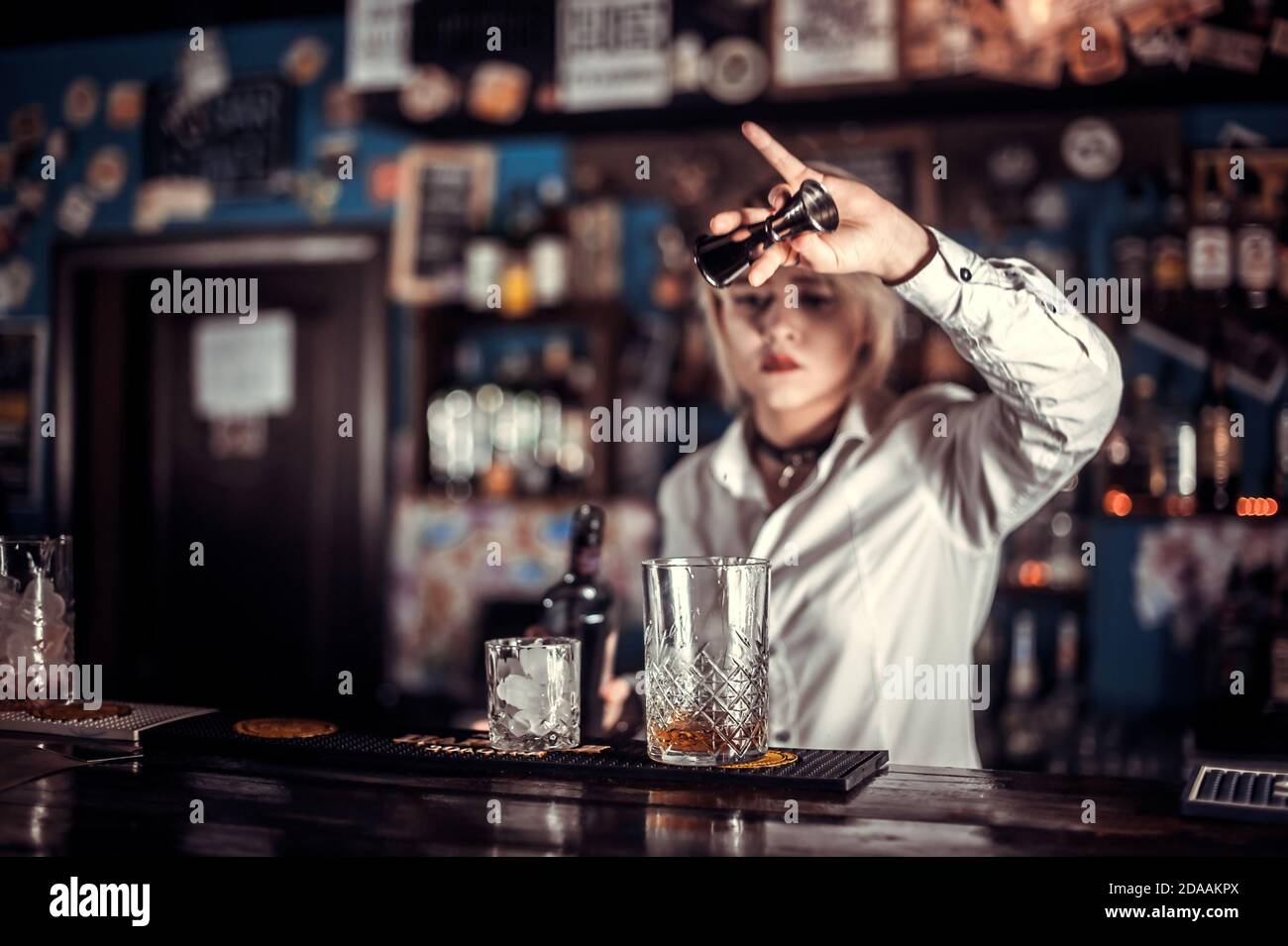 Professional woman bartending makes a show creating a cocktail behind ...