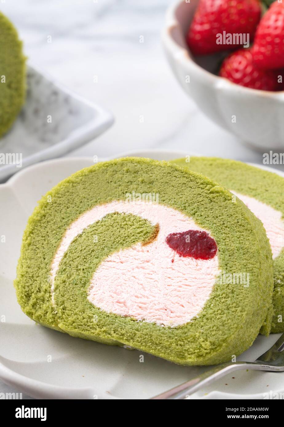 Delicious Matcha Swiss Roll Cake slices with strawberry icing cream on ...