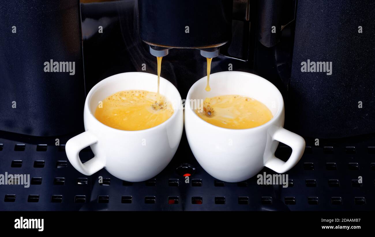 Two white cups with espresso preparation in coffee machine Stock Photo ...