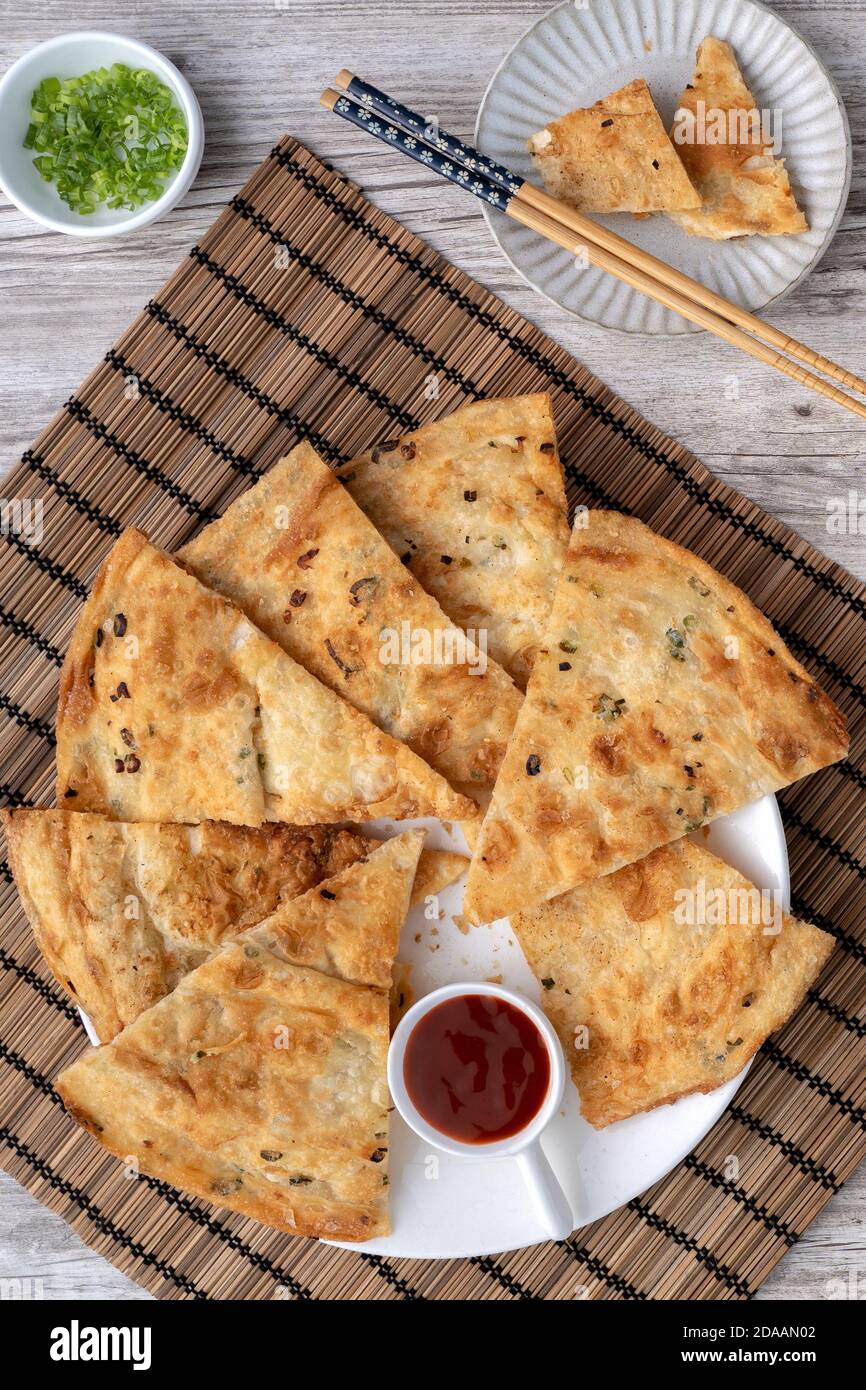 Taiwanese food - delicious flaky scallion pie pancakes on bright wooden ...