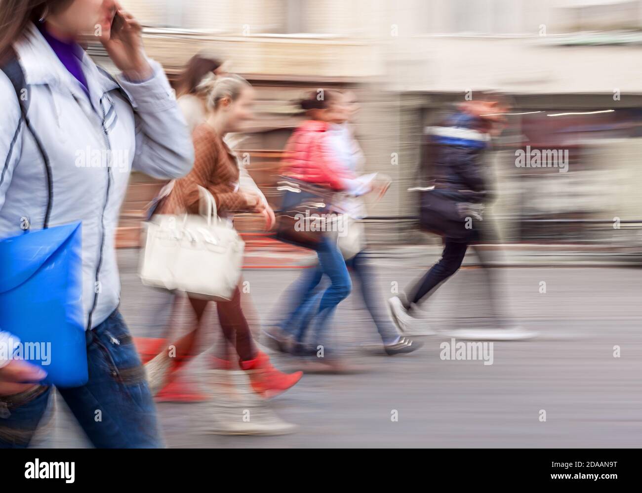 A group of young people going along the street. Intentional motion blur ...