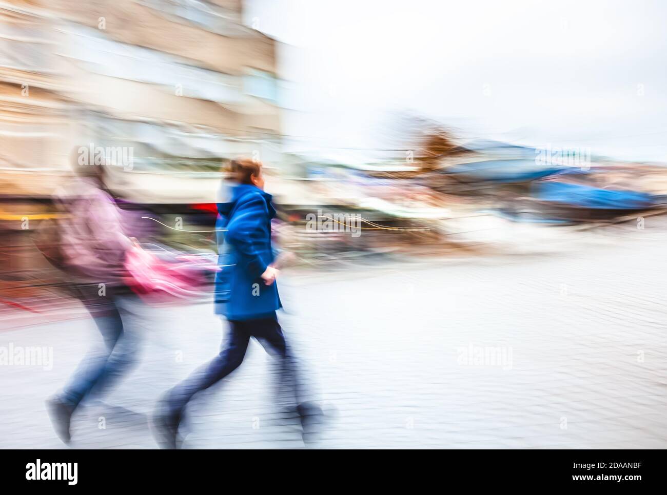 Abstract soft focus image of a group of young people hurrying about ...