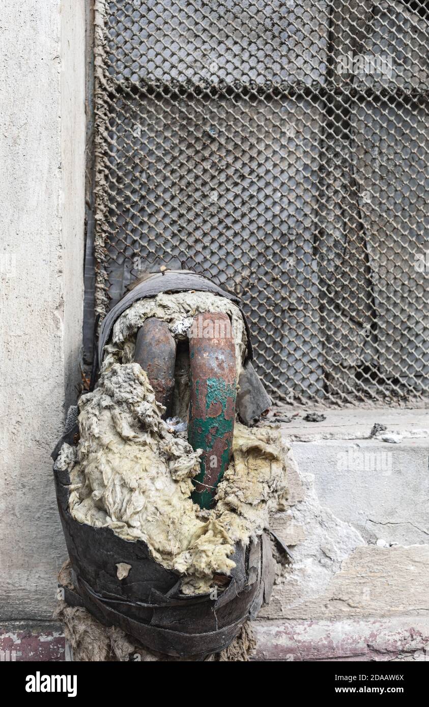 Rusty heat pipes with damaged insulation. Rusty heating system pipes ...