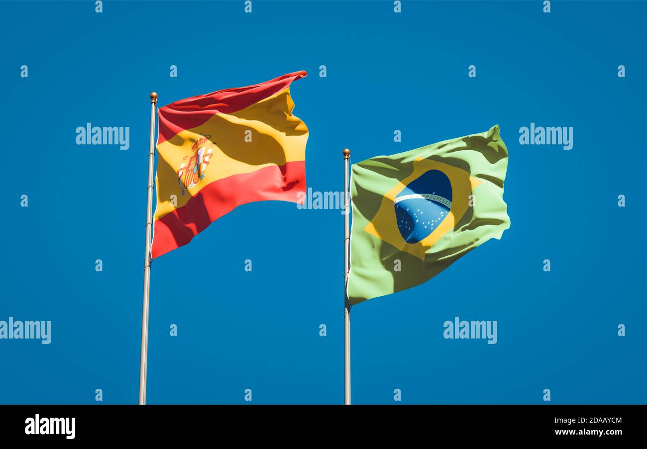 Beautiful national state flags of Spain and Brasil together at the sky ...