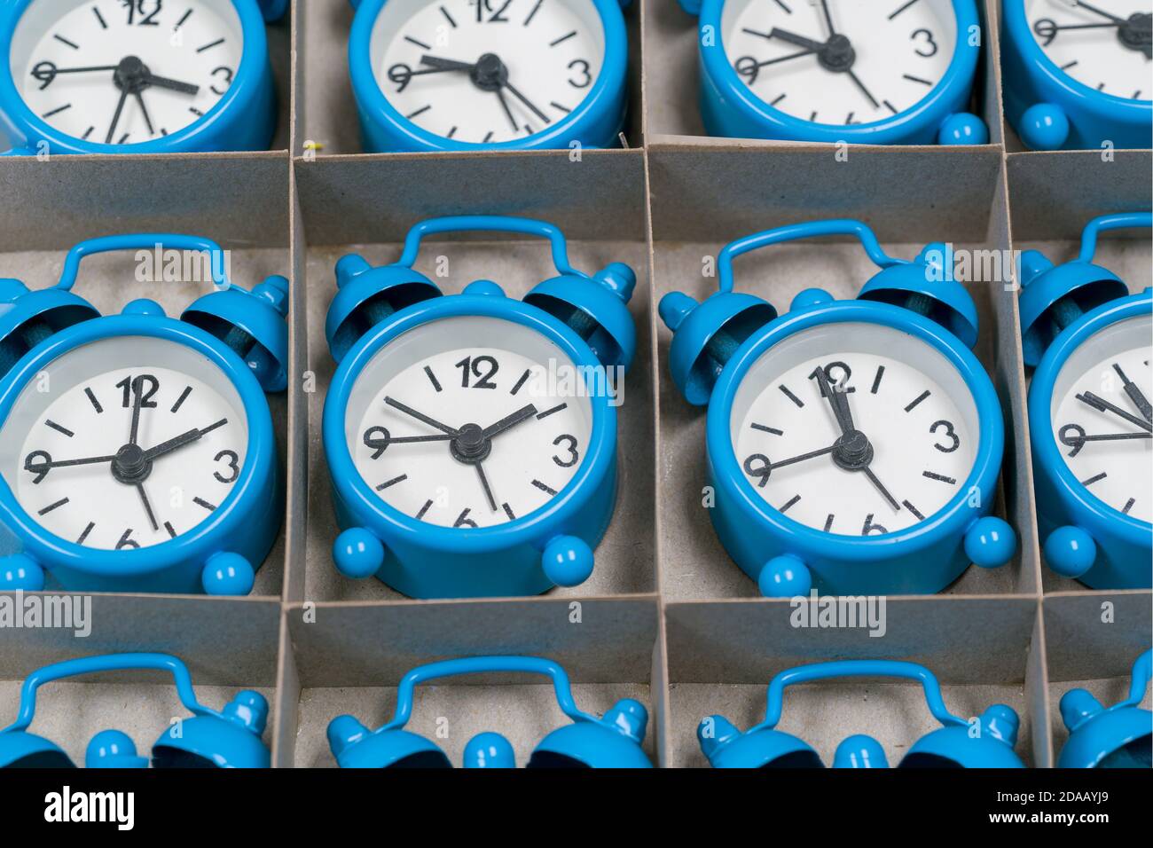Colored clock alarm clocks in a cardboard box Stock Photo - Alamy