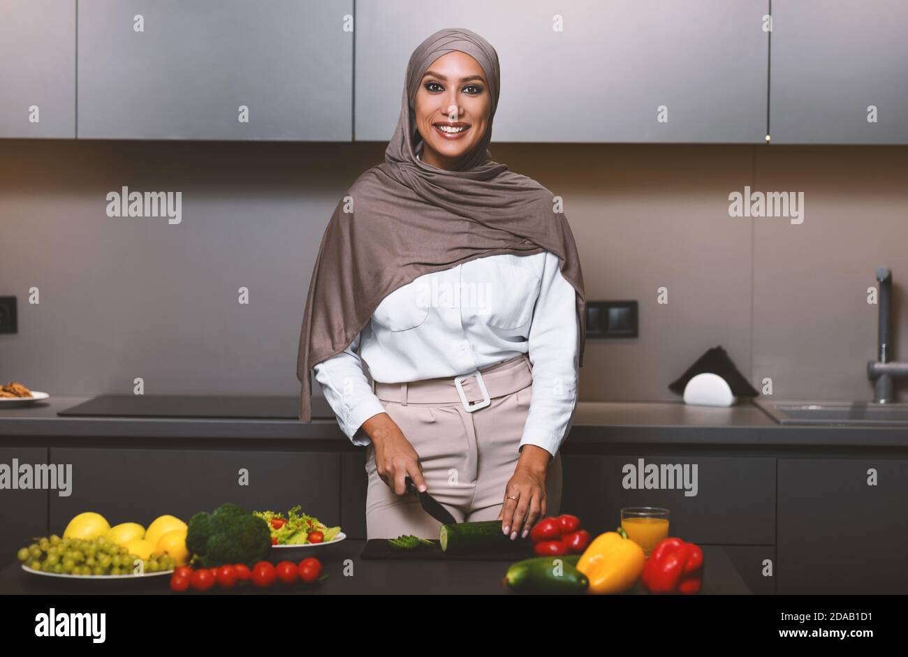 Happy Muslim Lady Cooking In Kitchen Making Salad For Dinner Stock ...