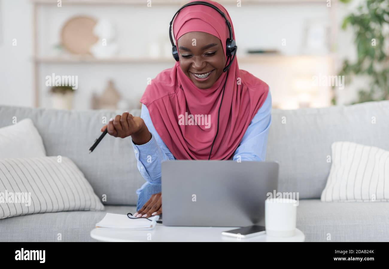 Young African Muslim Woman In Hijab Studying At Home With Online Tutor ...