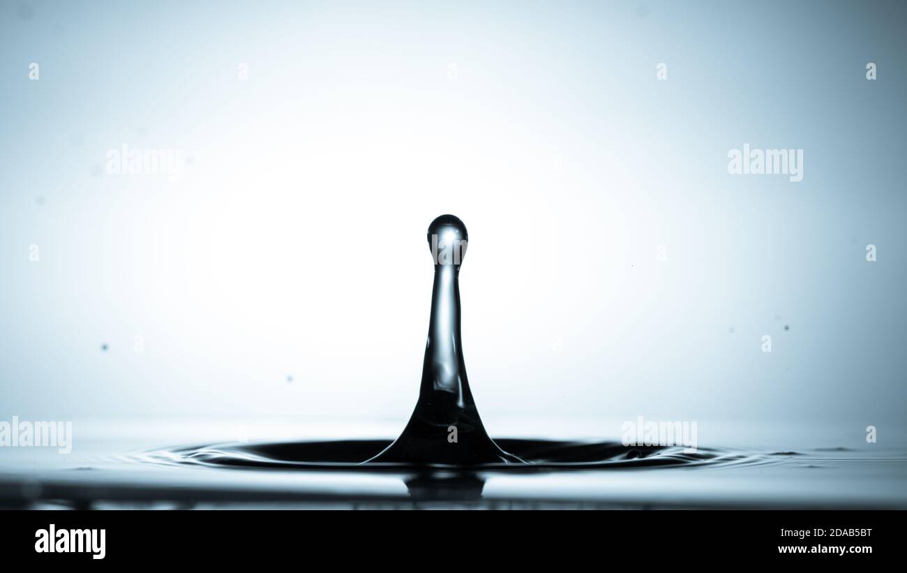 Close-up of a water drop falling on water surface Stock Photo - Alamy