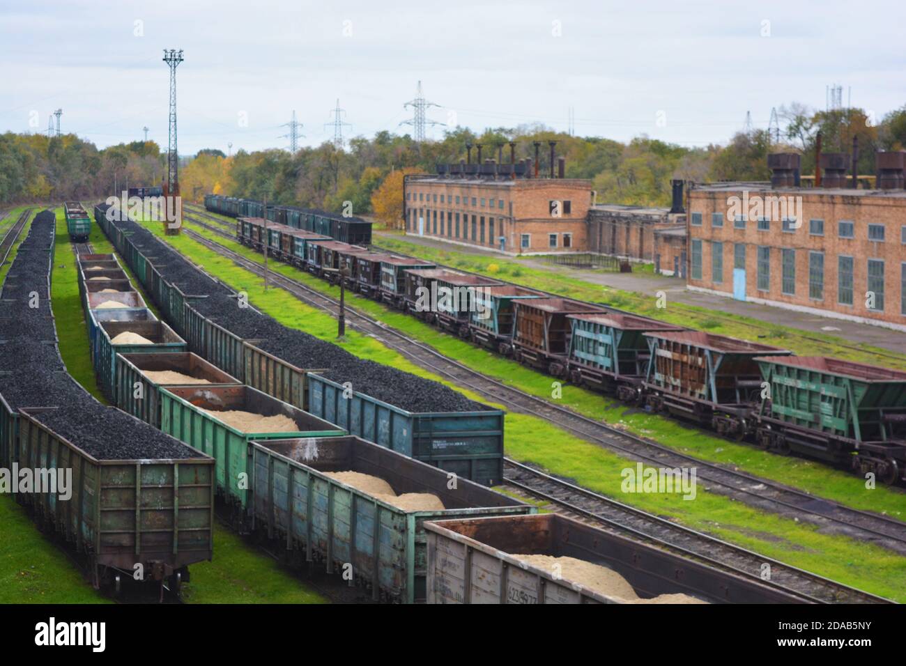Large metal wagons, railroad runs with small green grass located on the ...