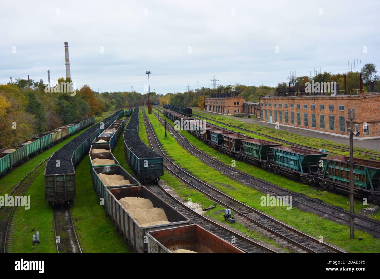 Large metal wagons, railroad runs with small green grass located on the ...