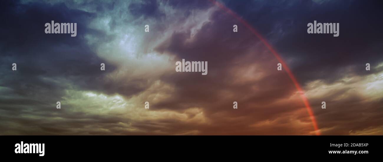 Rainbow in the sky against dark dramatic clouds Stock Photo - Alamy