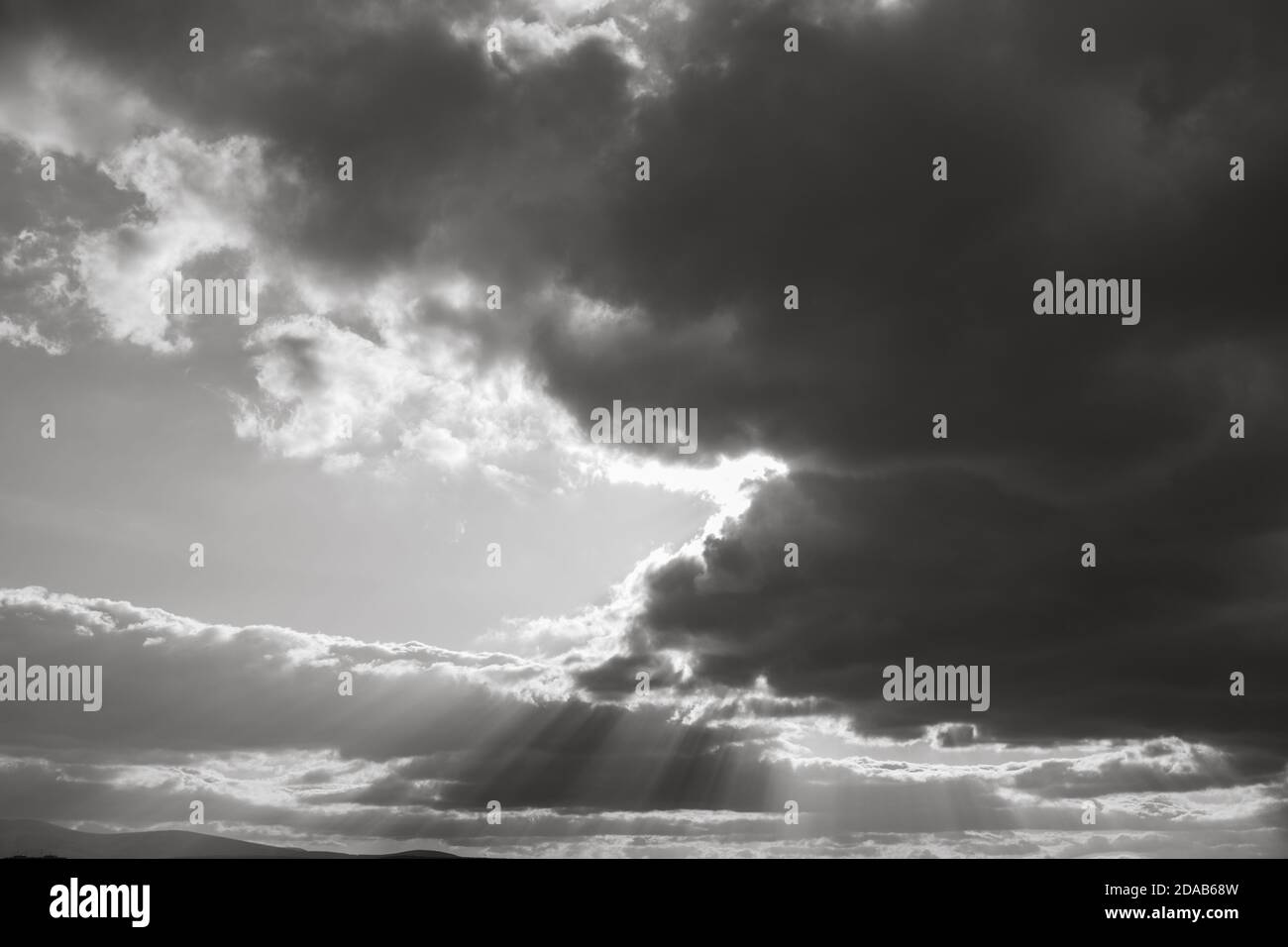 Sun rays shining through dark rainy clouds sky Stock Photo - Alamy