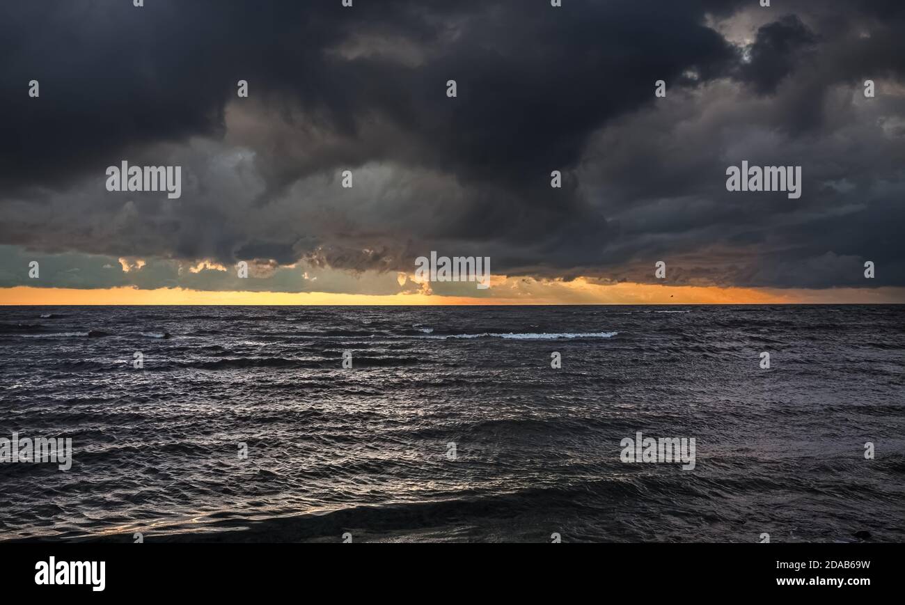 Amazing dramatic landscape. Dramatic dark clouds during sunset at sea ...