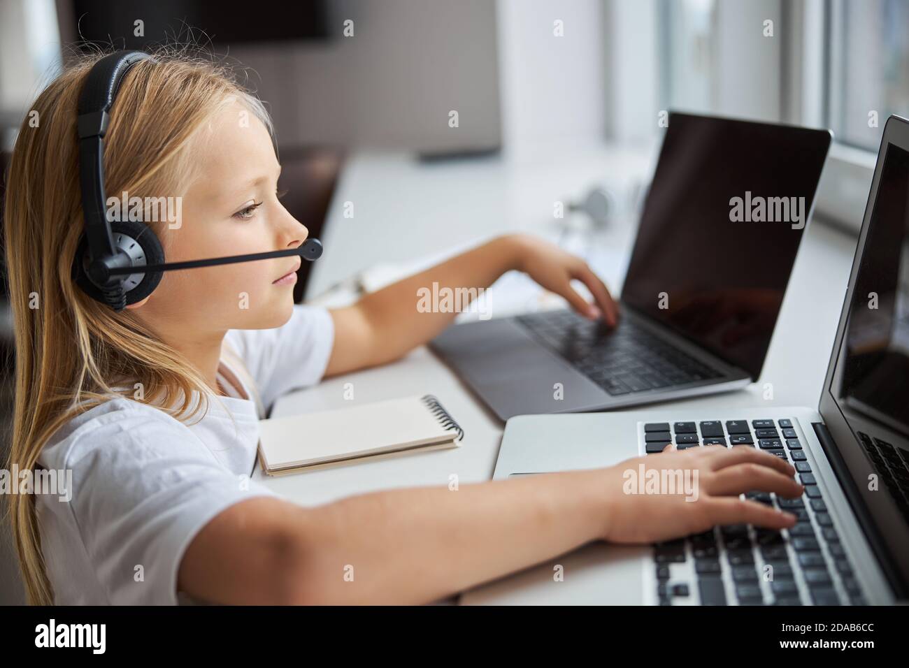 Clever little girl studying at the laptop from home Stock Photo - Alamy