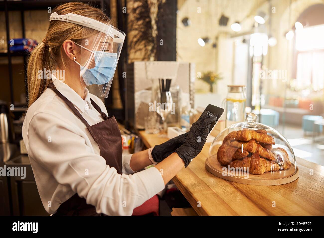 Waitress at the bar counter using modern device Stock Photo - Alamy