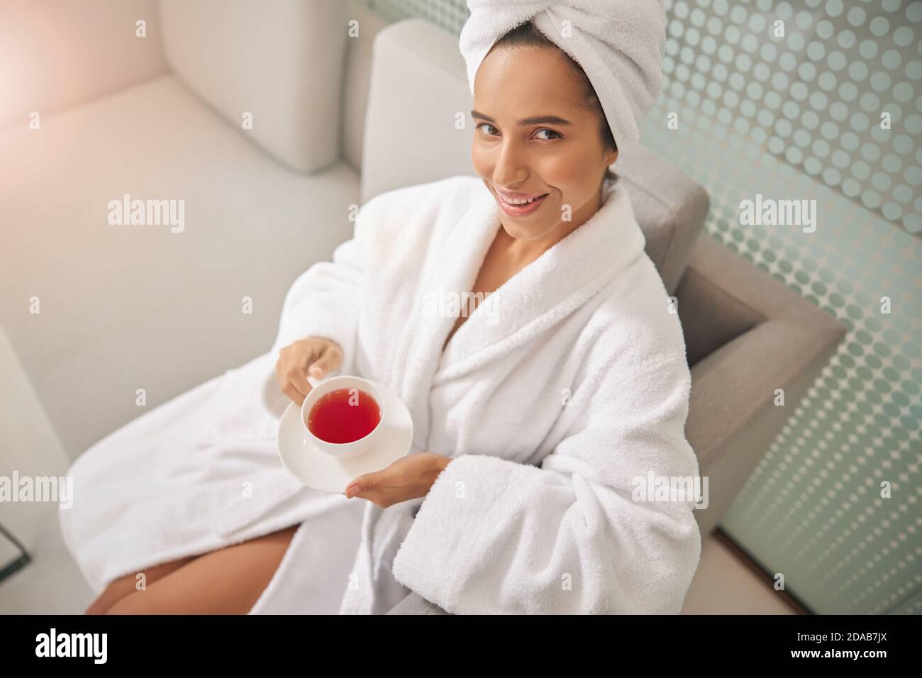 Smiling client feeling like at home in a white robe and towel Stock ...