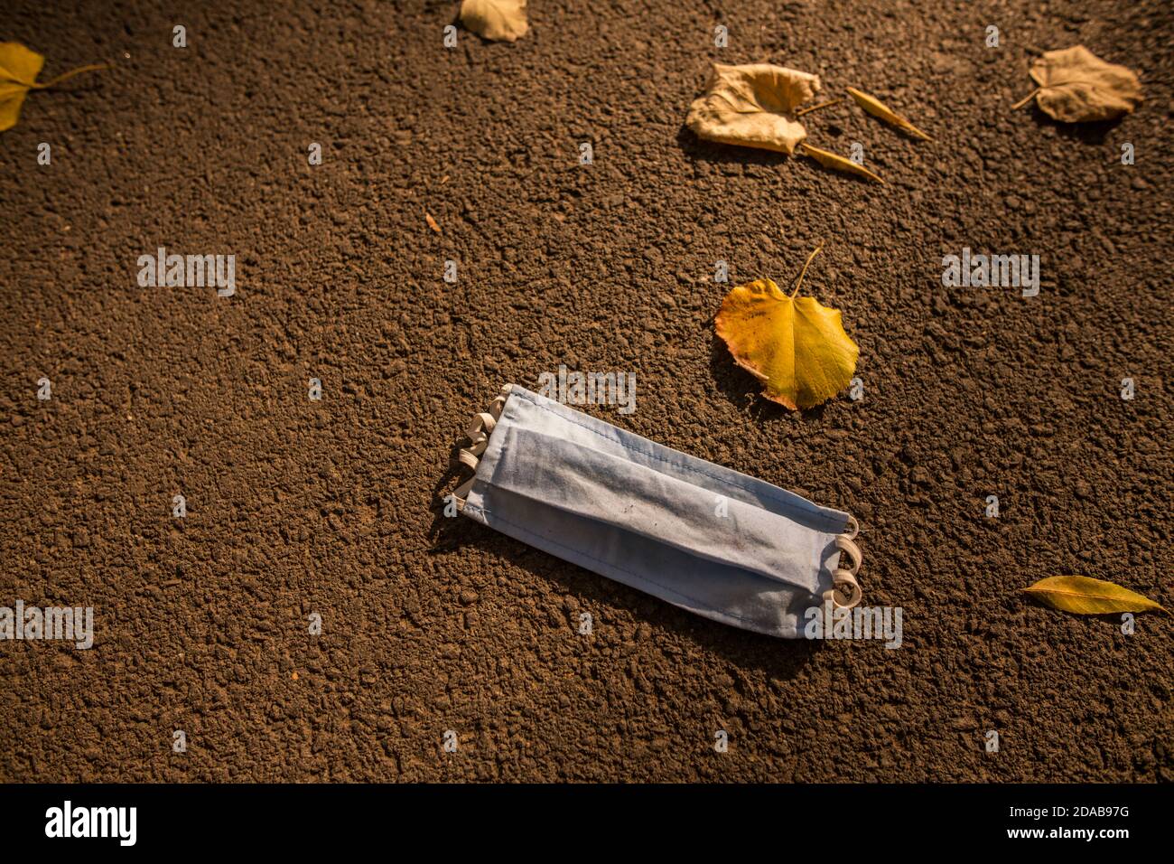 Close up shot of a used surgical mask, lying on the ground ...