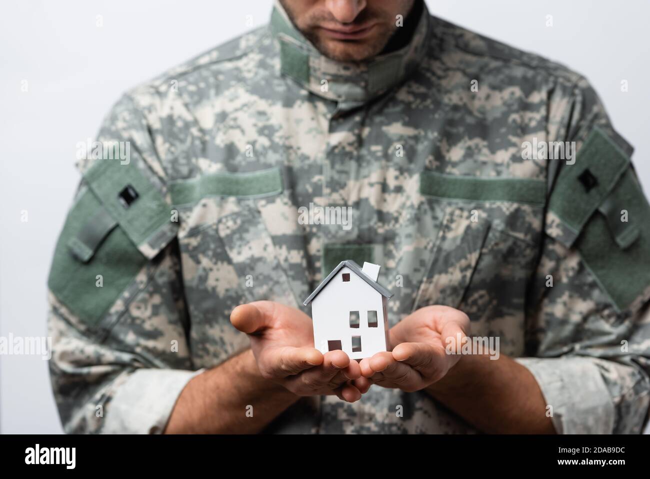 house model in hands of patriotic military man in uniform on blurred ...