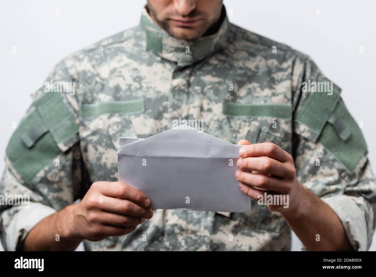 envelope in hands of patriotic military man in uniform on blurred ...