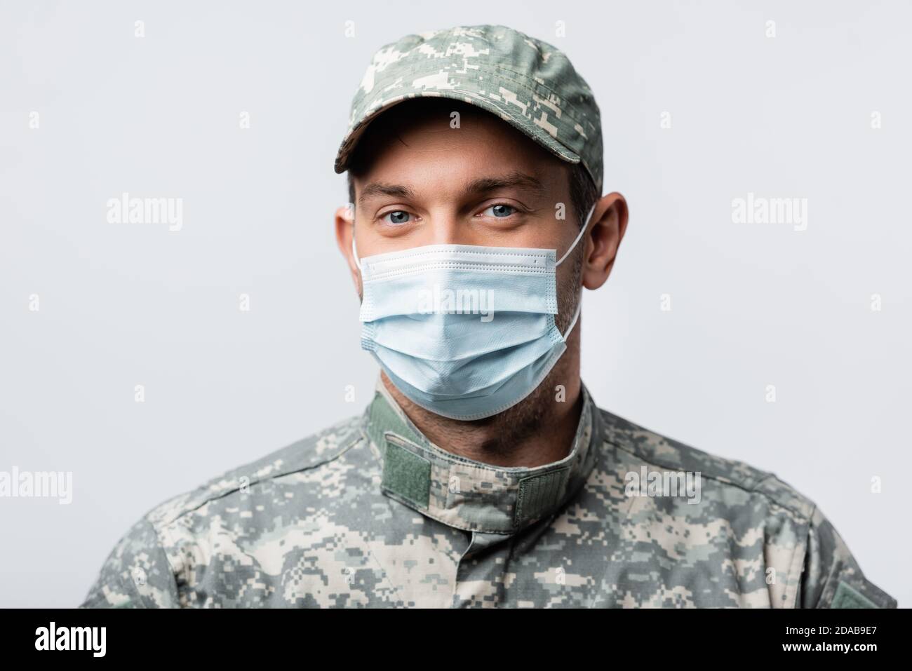 military man in uniform and medical mask looking at camera isolated on ...