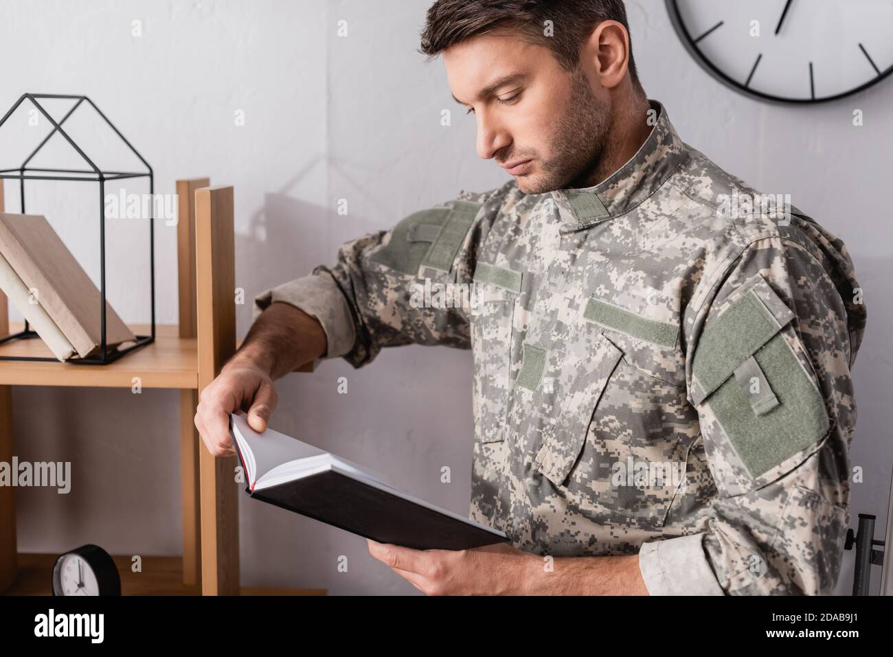 serious military man in uniform holding notepad near wooden rack Stock ...