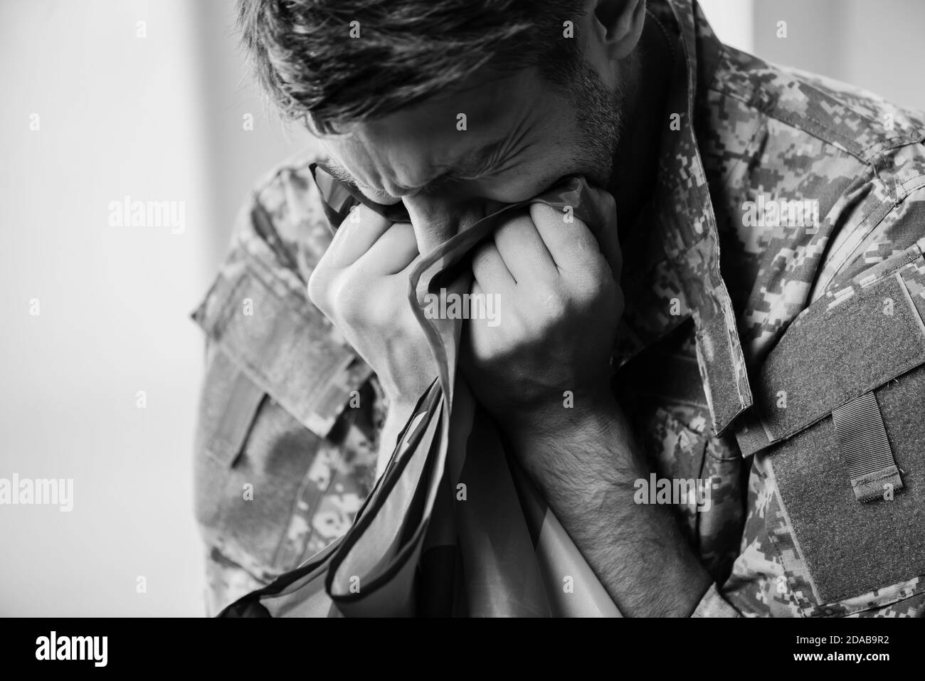 military man in uniform crying while holding american flag, monochrome ...