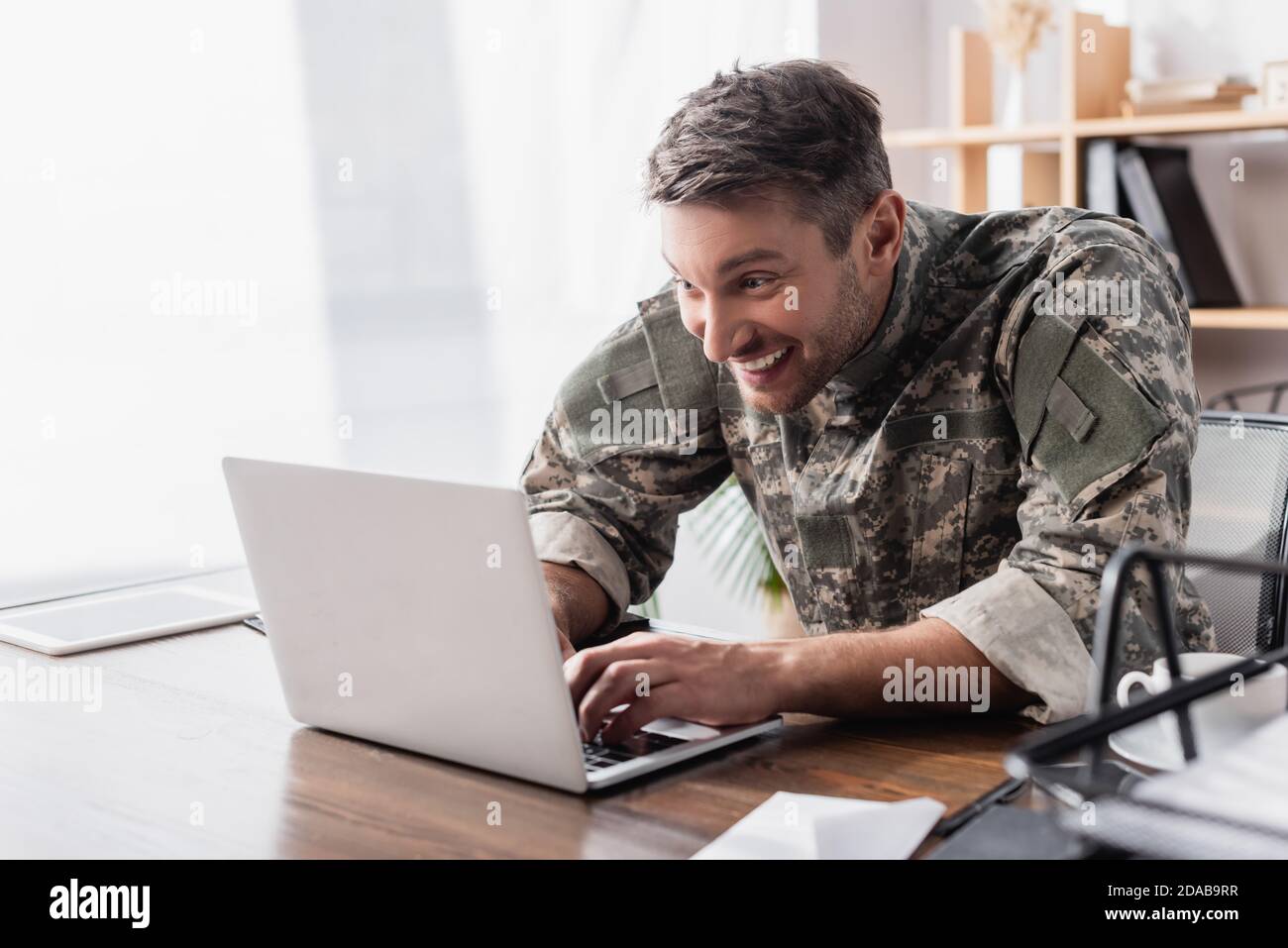 excited military man typing on laptop keyboard Stock Photo - Alamy