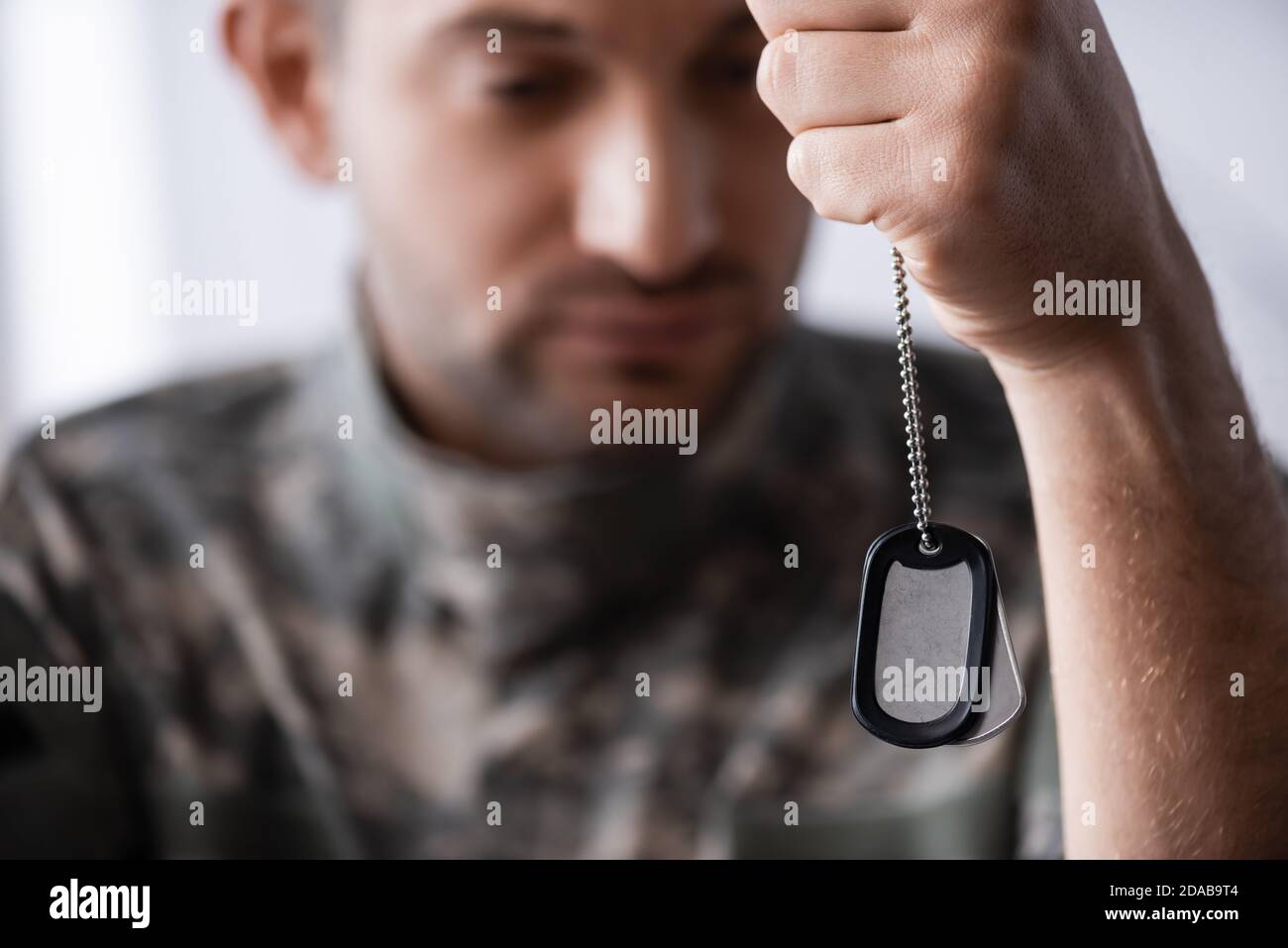 military tag in hand on soldier on blurred background Stock Photo - Alamy