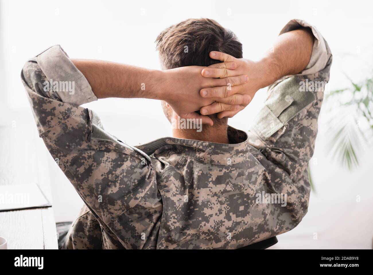 back view of soldier in military uniform with hands behind back resting ...
