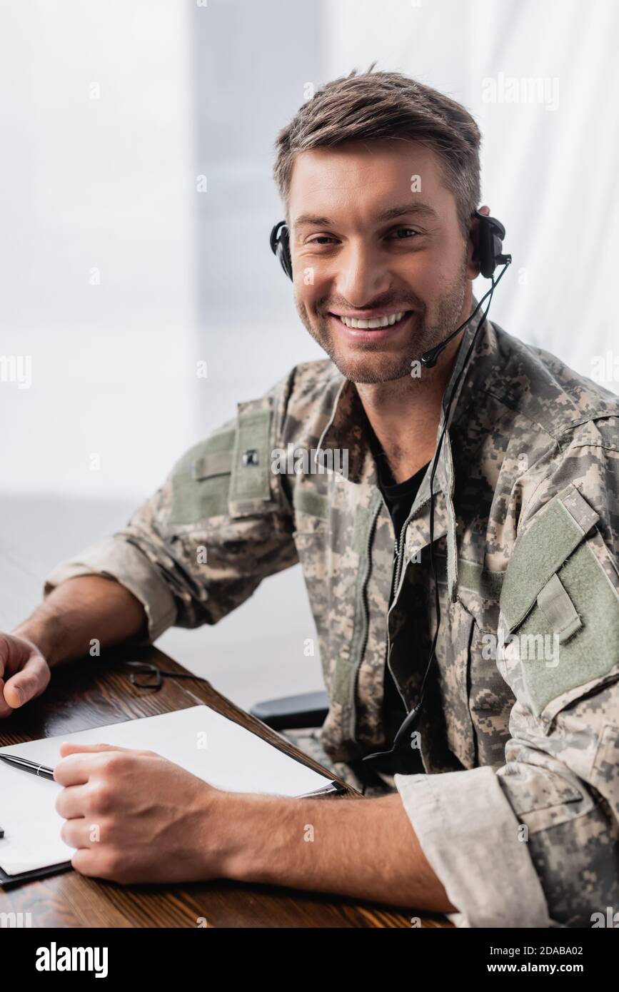 positive military man in uniform and headset smiling in office Stock ...