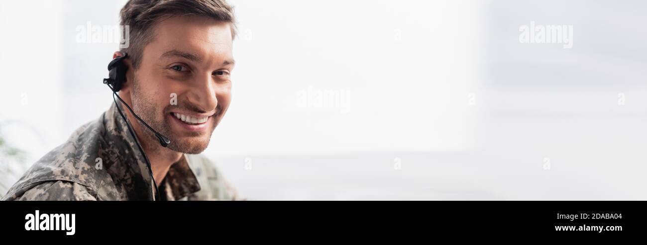 happy military man in uniform and headset smiling in office, banner ...