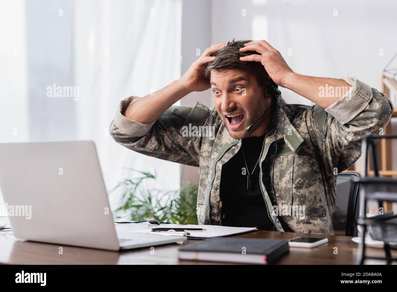 shocked military man in uniform and headset looking at laptop Stock ...