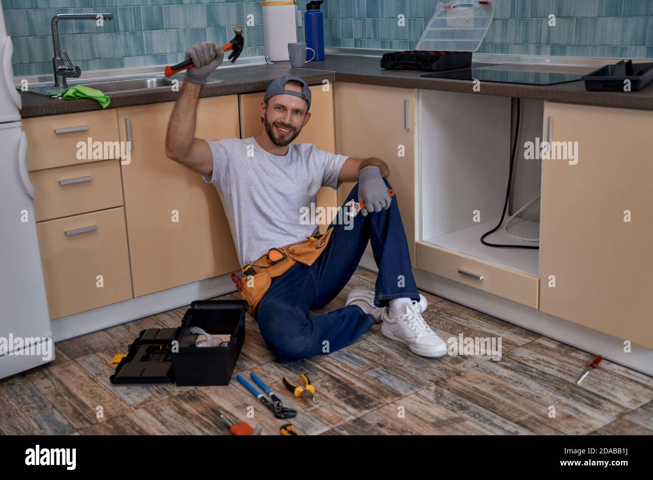 Happy young caucasian worker with raised hand holding hammer Stock ...