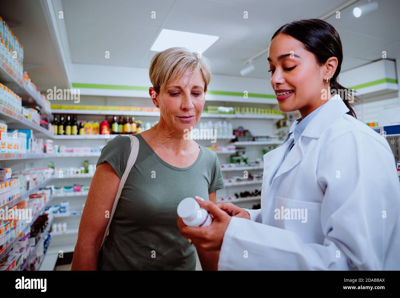 Caucasian mother getting assistance from mixed race pharmacist ...