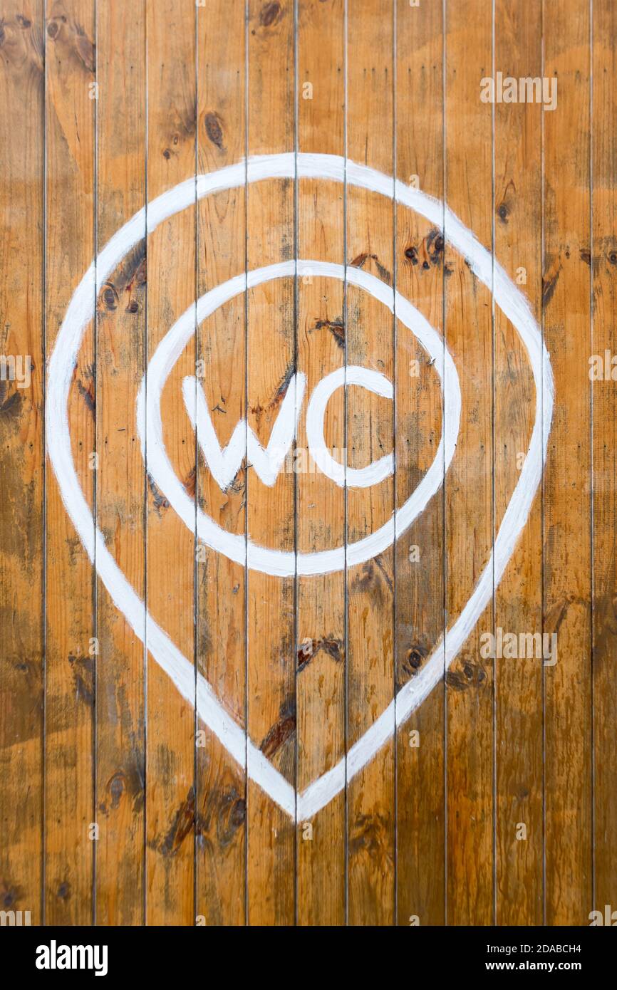 WC sign with white painted text on wooden wall Stock Photo - Alamy